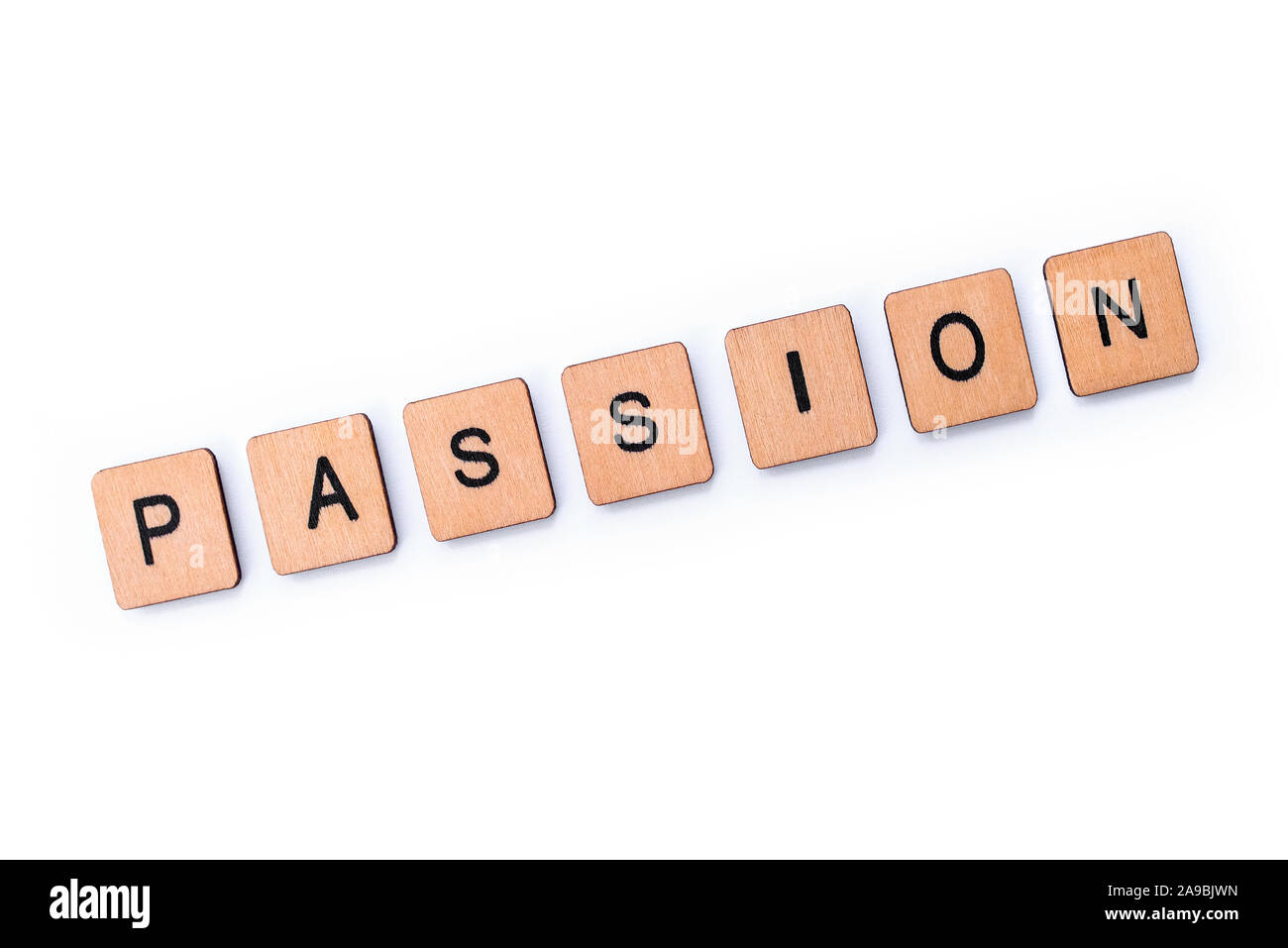 The word PASSION, spelt with wooden letter tiles over a white ...