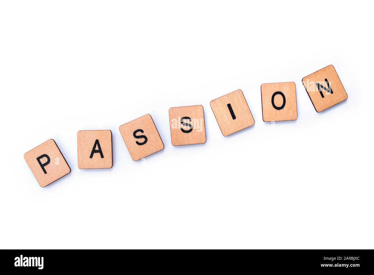 The word PASSION, spelt with wooden letter tiles over a white ...