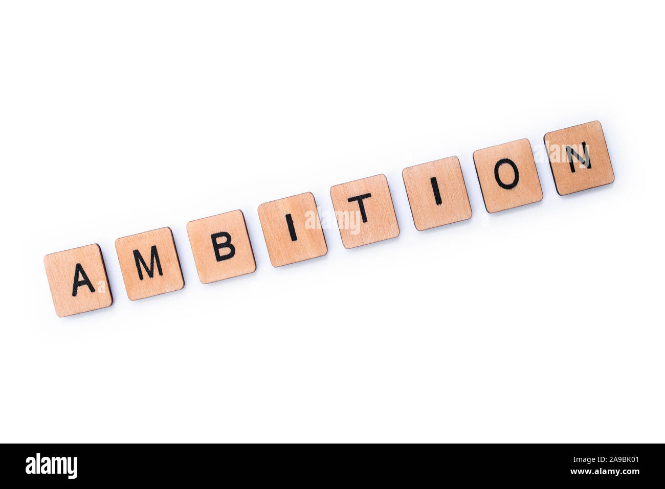 The word AMBITION, spelt with wooden letter tiles over a white ...