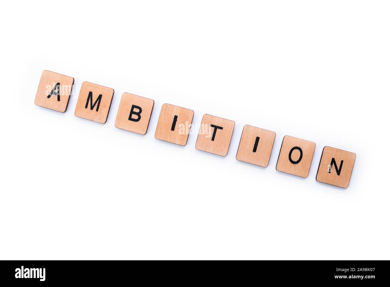 The word AMBITION, spelt with wooden letter tiles over a white ...