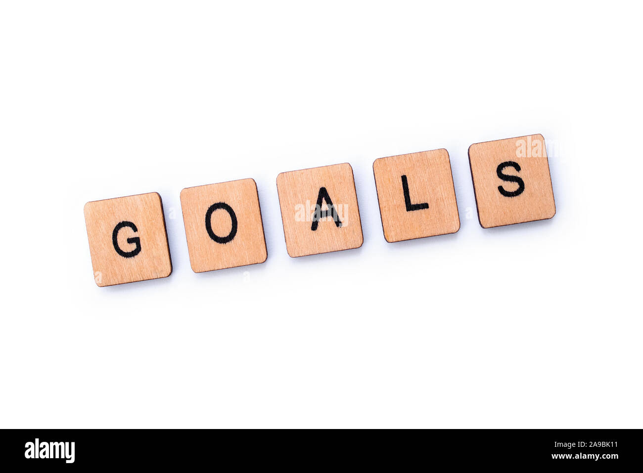 The word GOALS, spelt with wooden letter tiles over a white background ...
