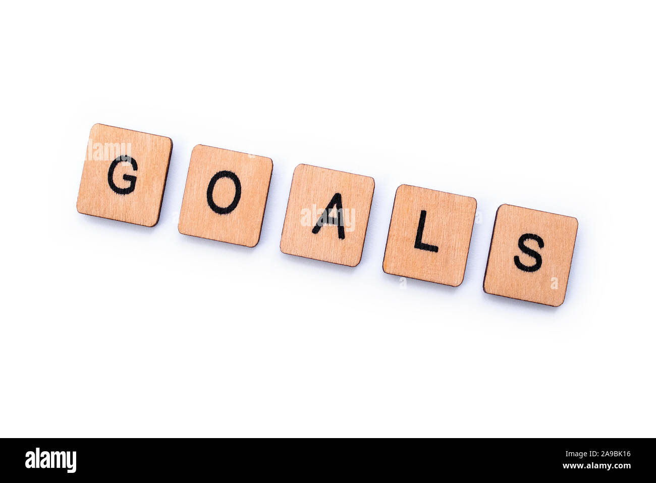 The word GOALS, spelt with wooden letter tiles over a white background ...