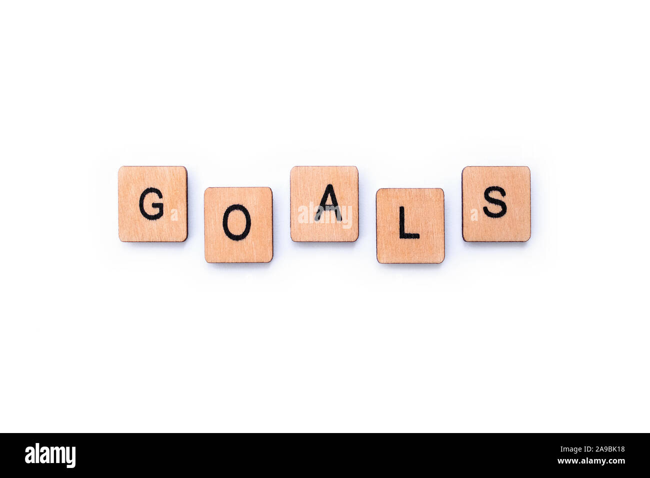 The word GOALS, spelt with wooden letter tiles over a white background ...