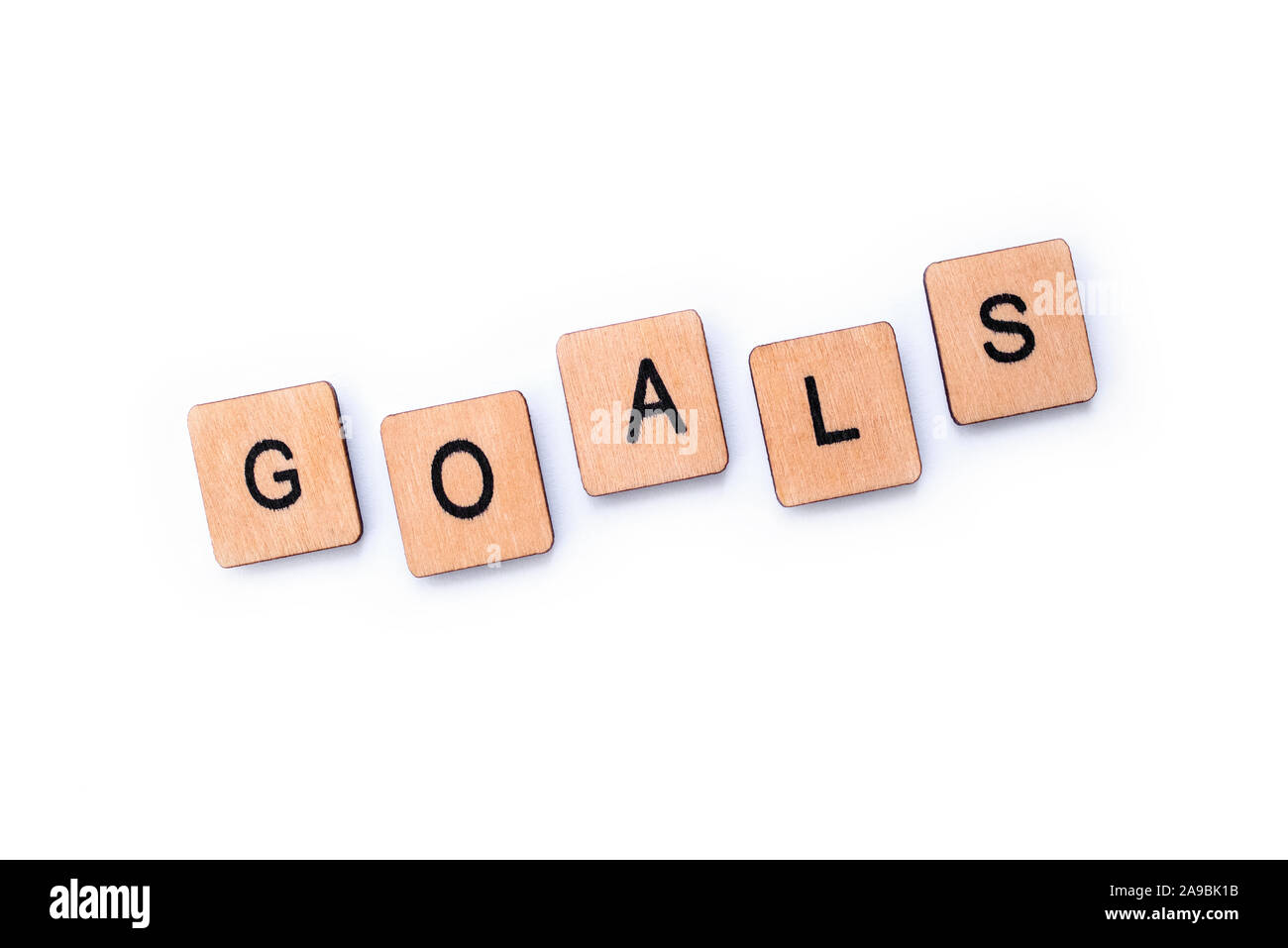 The word GOALS, spelt with wooden letter tiles over a white background ...