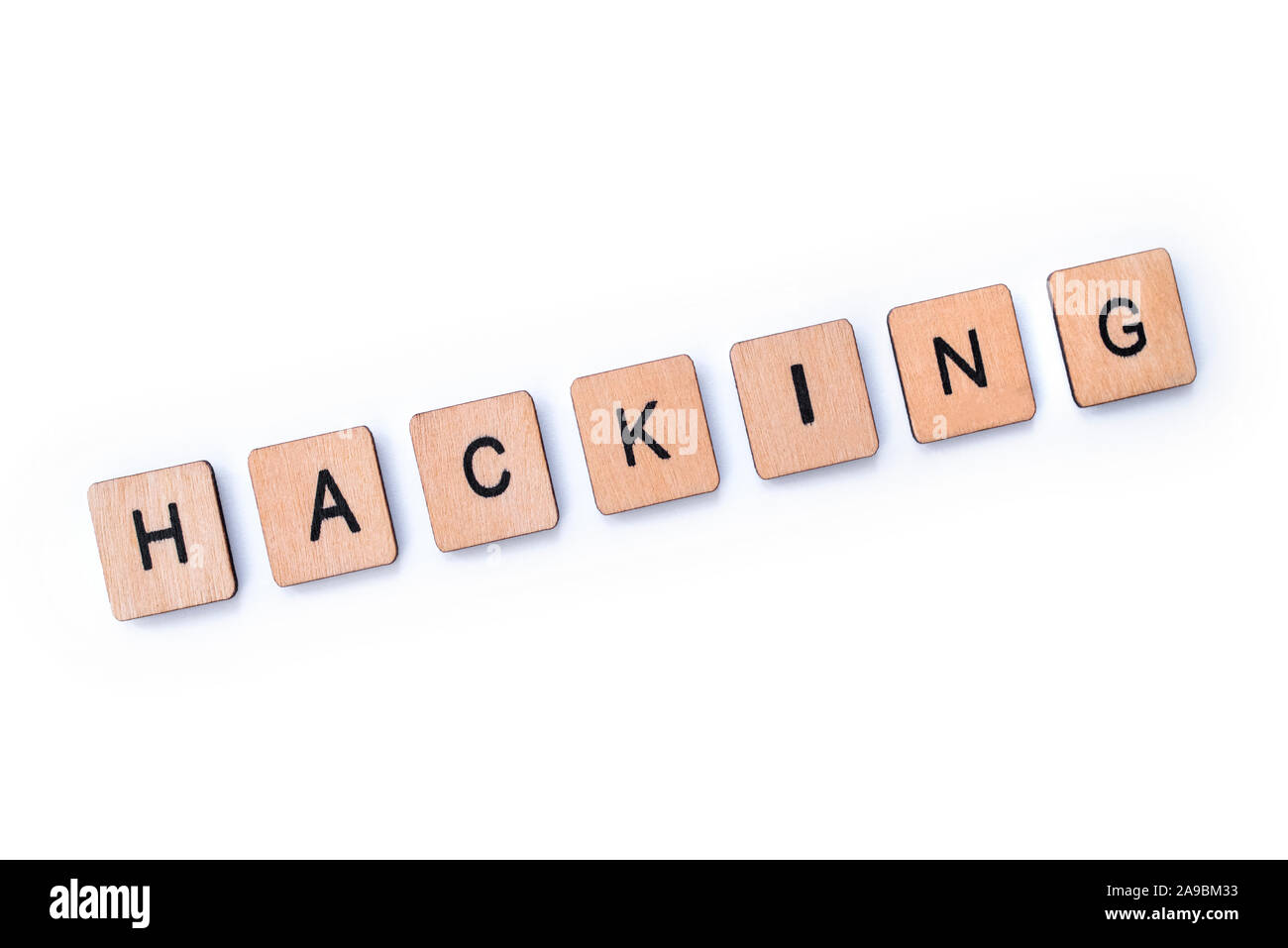 The word HACKING, spelt with wooden letter tiles over a white ...