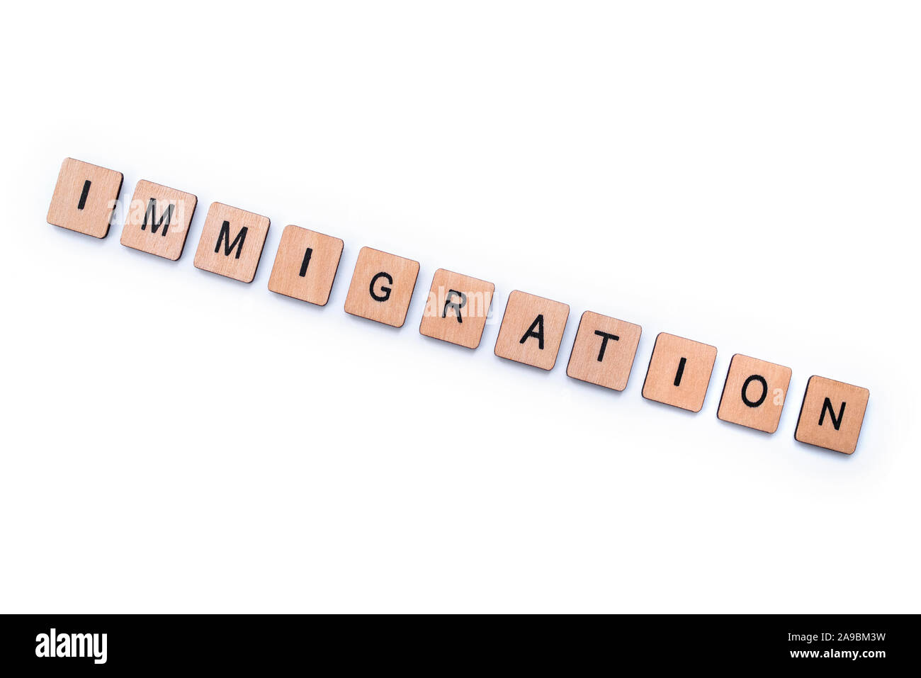 The word IMMIGRATION, spelt with wooden letter tiles over a white ...