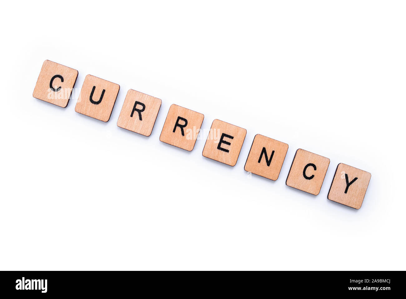 The word CURRENCY, spelt with wooden letter tiles over a white ...