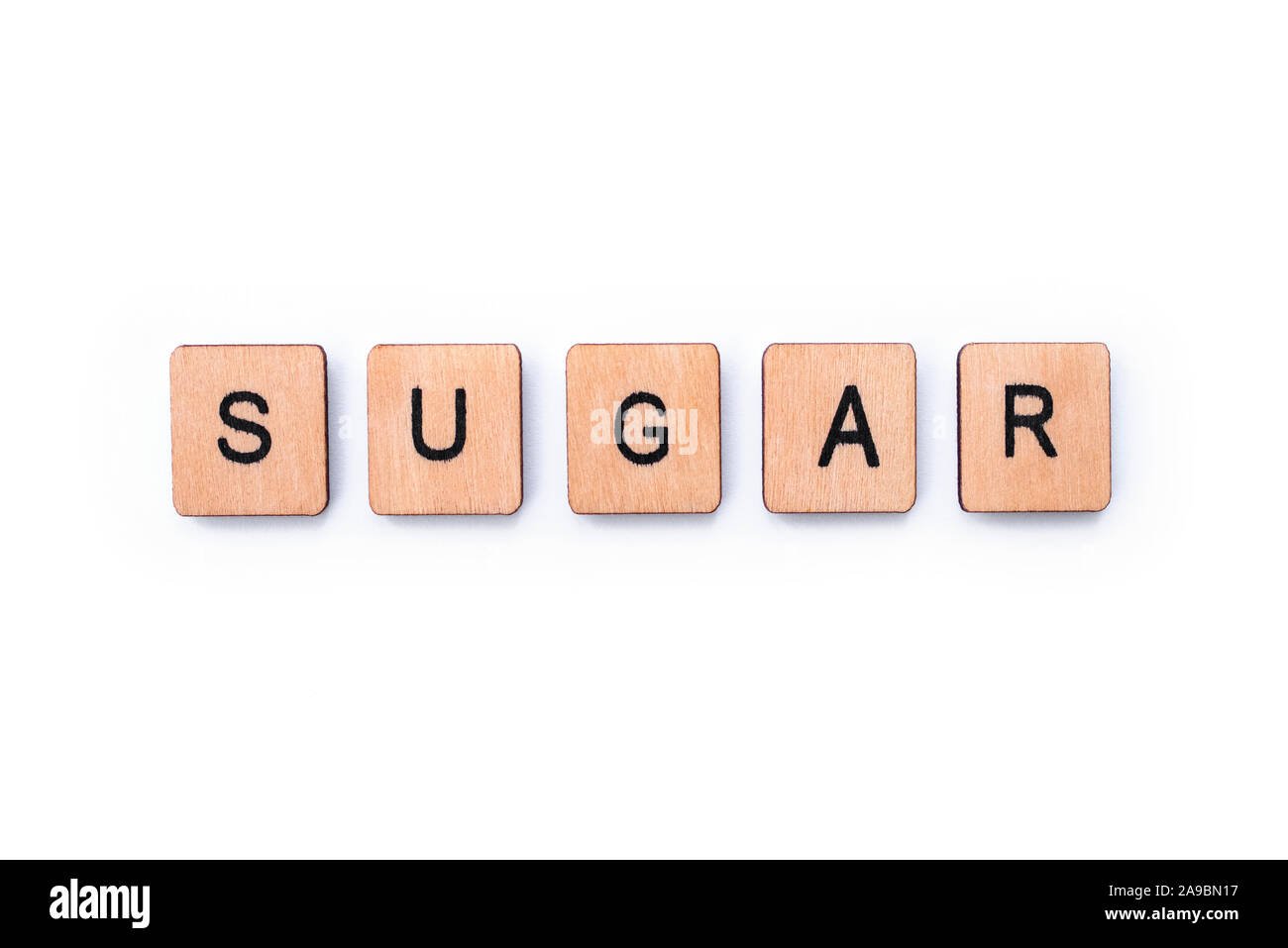 The word SUGAR, spelt with wooden letter tiles over a white background ...