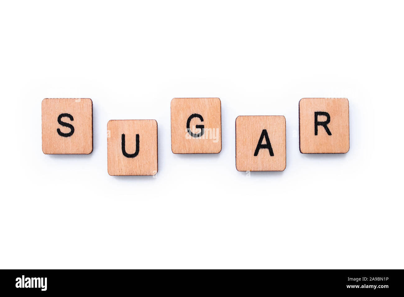 The word SUGAR, spelt with wooden letter tiles over a white background ...