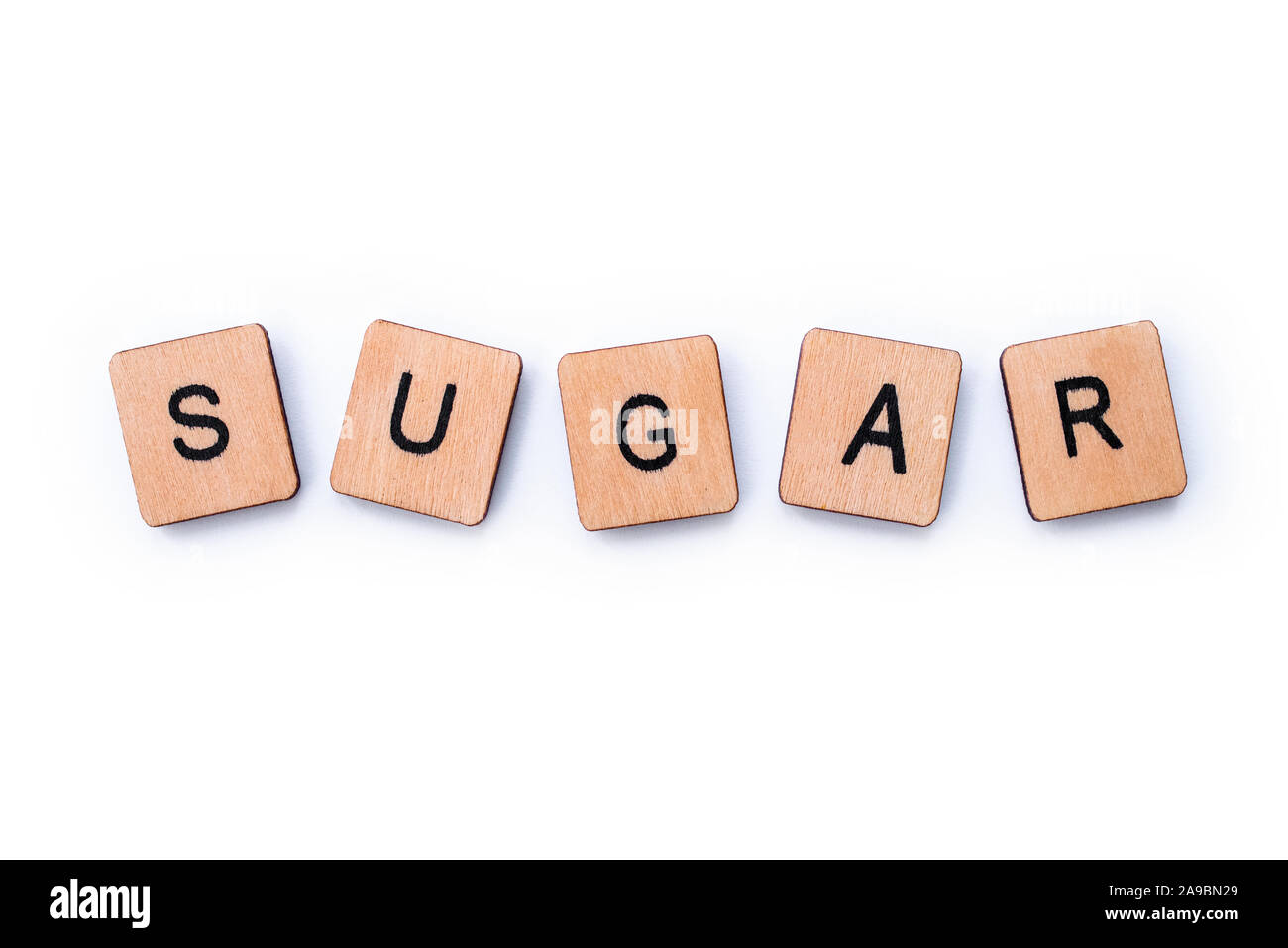 The word SUGAR, spelt with wooden letter tiles over a white background ...