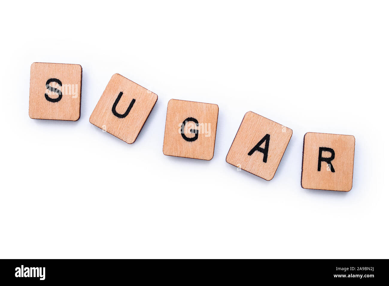 The word SUGAR, spelt with wooden letter tiles over a white background ...