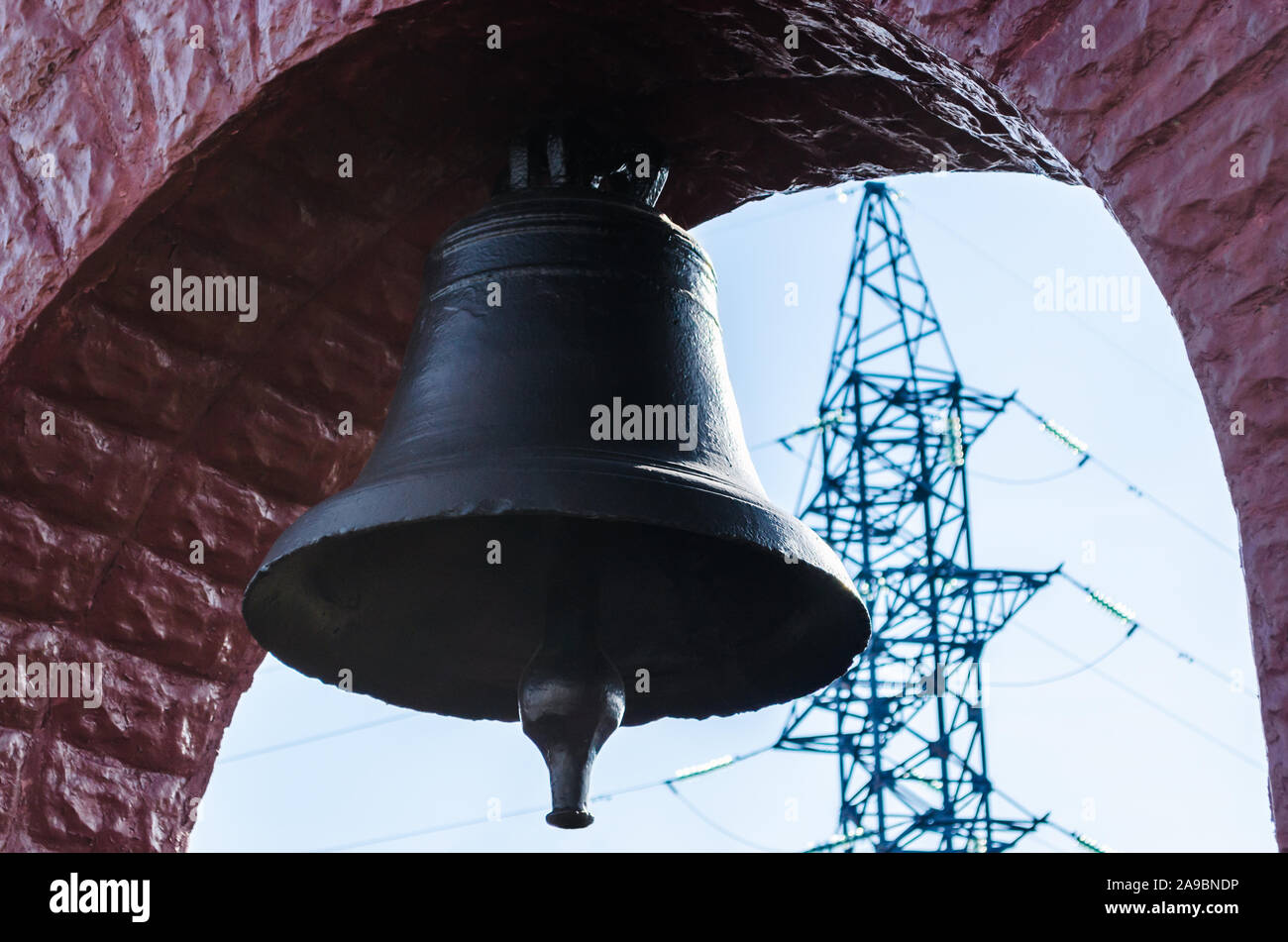 church christian bell with arch on a background of blue sky and power ...