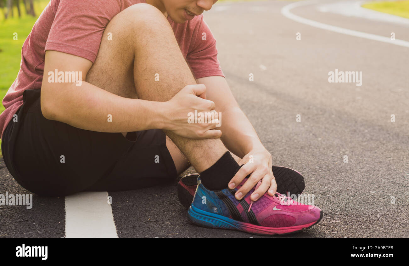 Ankle sprained. Young man suffering from an ankle injury while running ...
