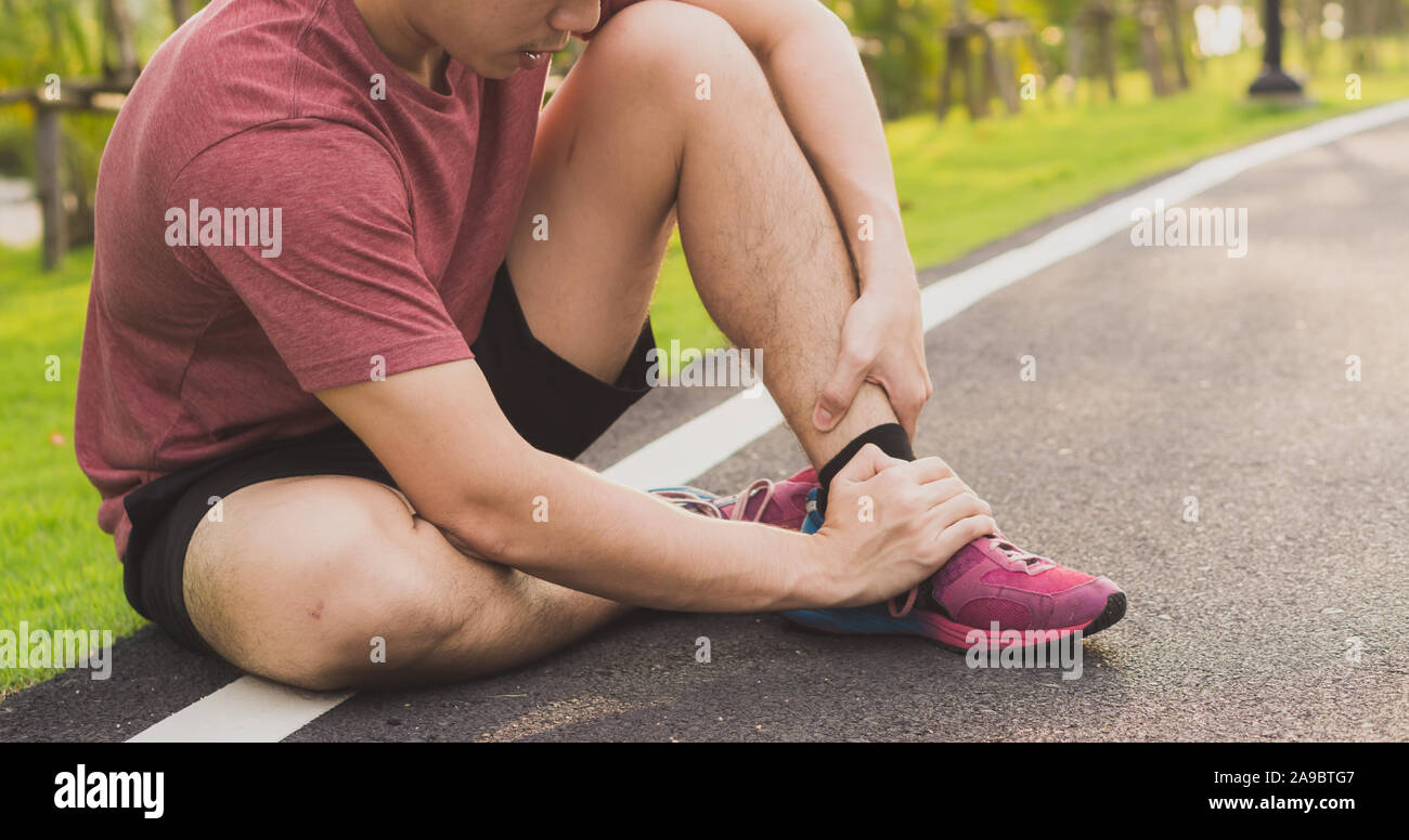 Ankle sprained. Young man suffering from an ankle injury while running ...