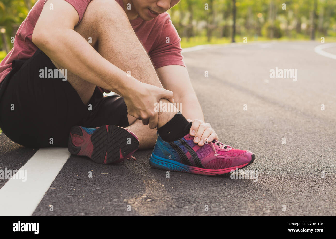 Ankle sprained. Young man suffering from an ankle injury while running ...