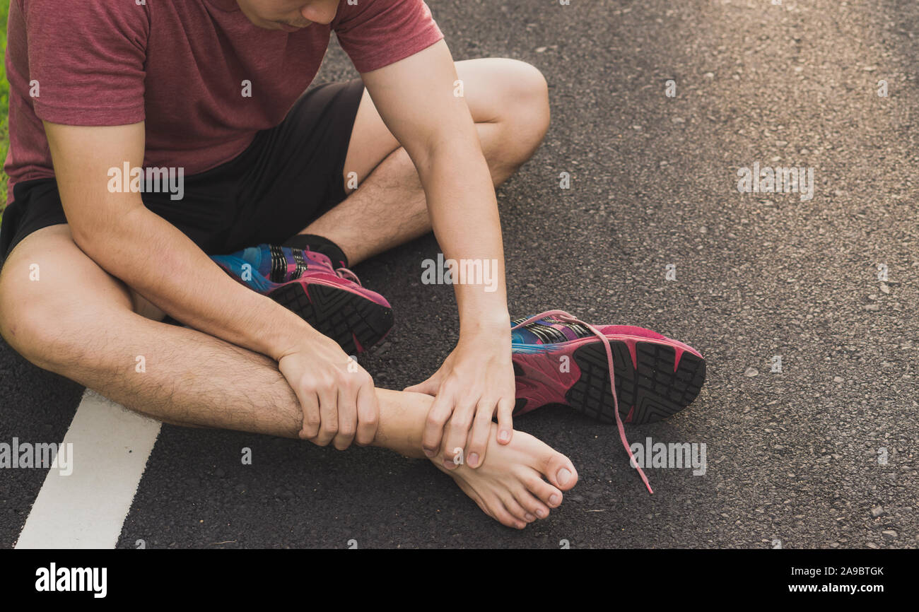 Ankle sprained. Young man suffering from an ankle injury while running ...