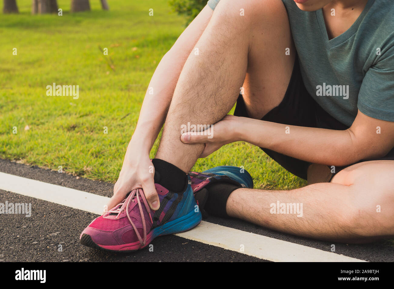 Ankle sprained. Young man suffering from an ankle injury while running ...