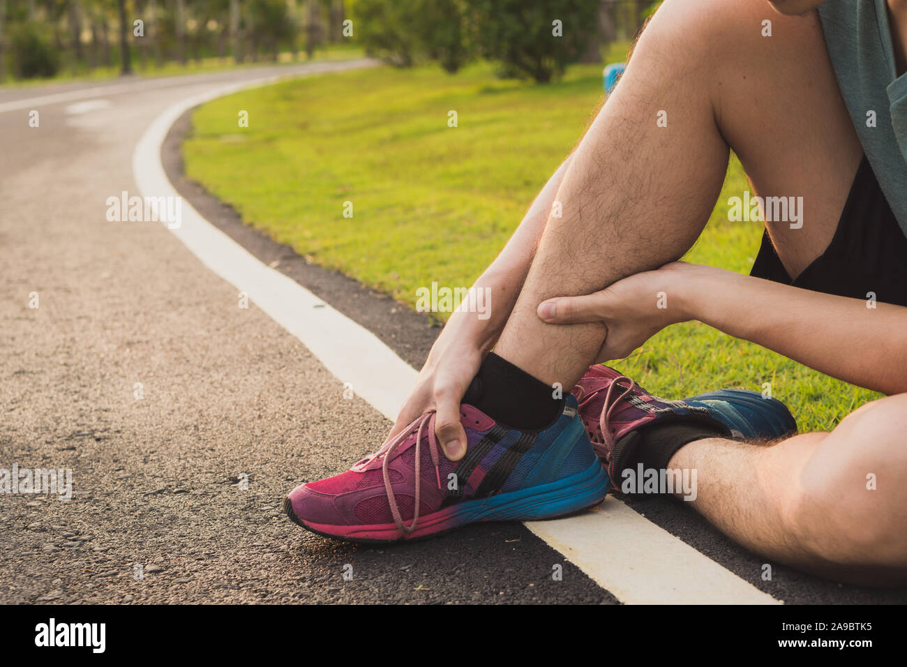 Ankle sprained. Young man suffering from an ankle injury while running ...