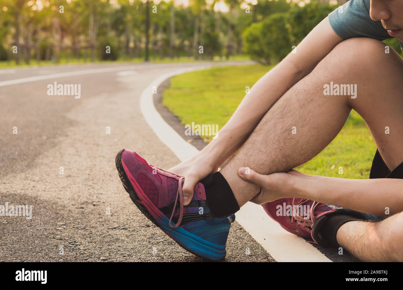 Ankle sprained. Young man suffering from an ankle injury while running ...