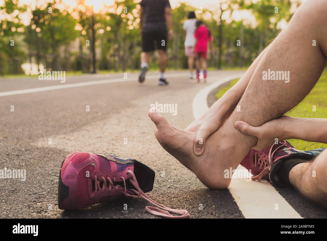 Ankle sprained. Young man suffering from an ankle injury while running ...