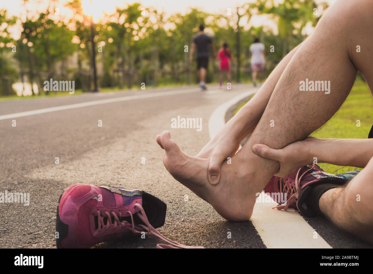 Ankle sprained. Young man suffering from an ankle injury while running ...