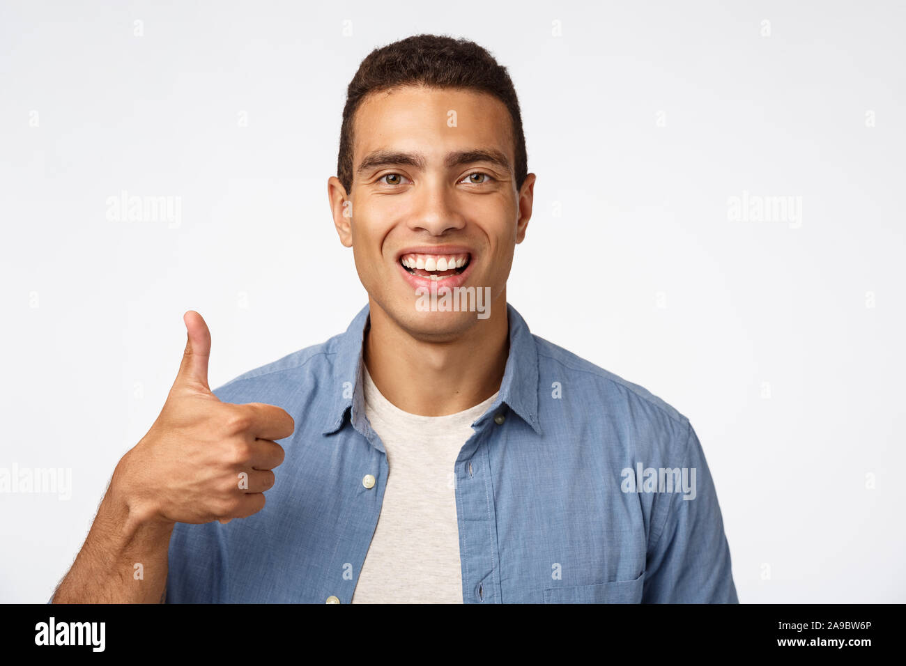 Supportive good-looking hispanic man showing thumbs-up, like idea ...