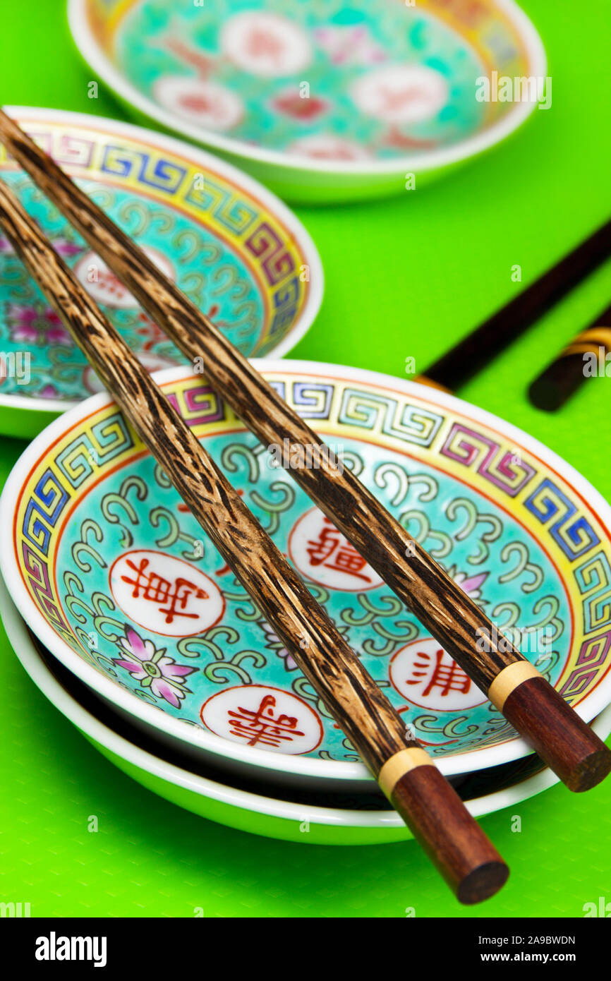 Asian dishes and sticks on green background Stock Photo - Alamy