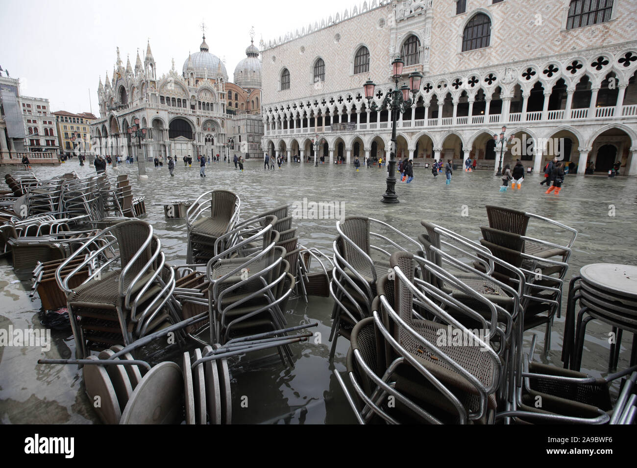 Venice, Italy. 13th Nov, 2019. People walk across the flooded San Marco ...