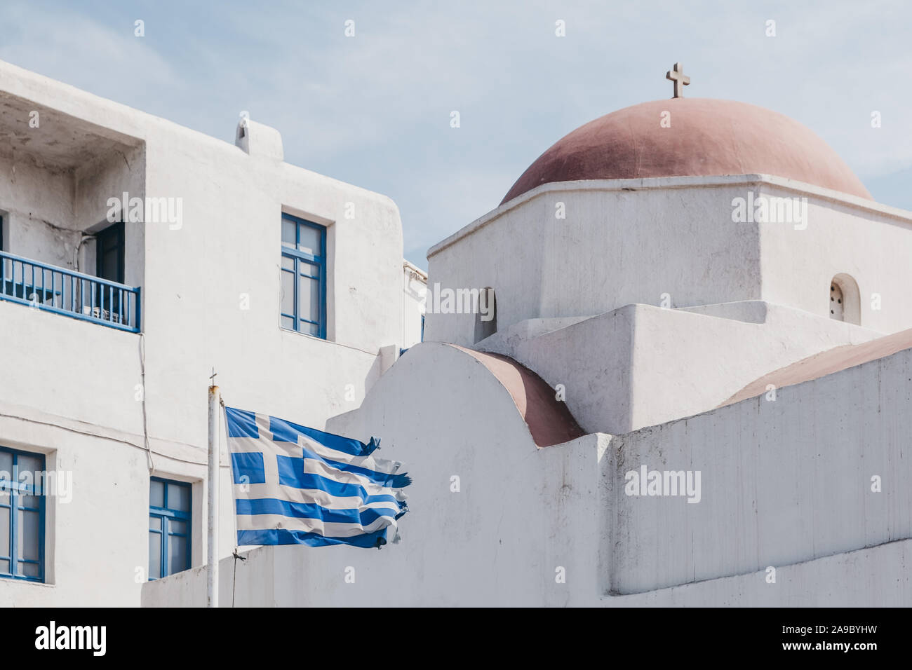 Greek flag in the wind outside the traditional Mykonian church with red ...
