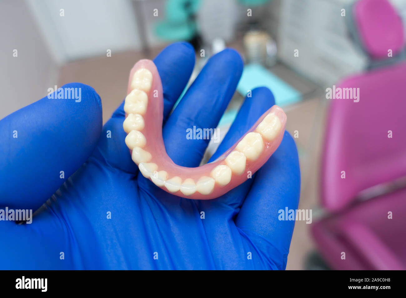 removable denture in the hands of a doctor in blue gloves Stock Photo ...