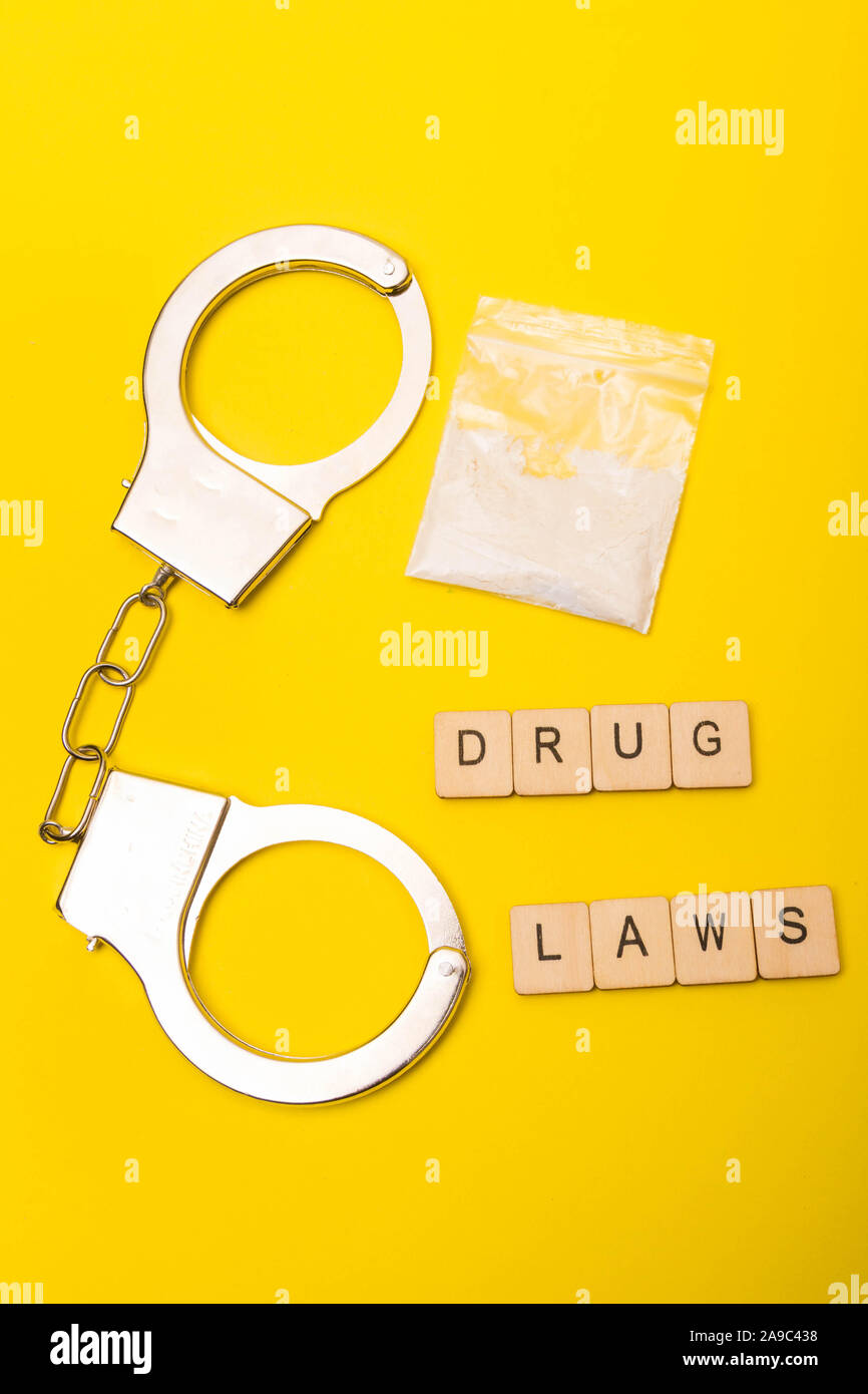Crime or justice concept showing a packet of drugs on a yellow ...