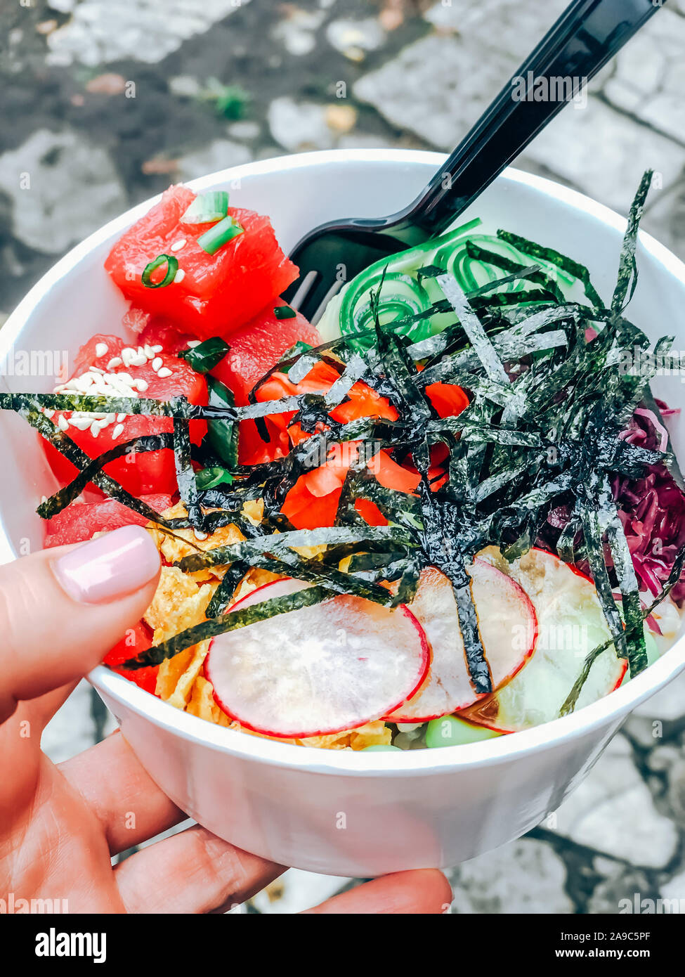 Poke bowl with tuna fish in disposable paper container. Woman hand ...