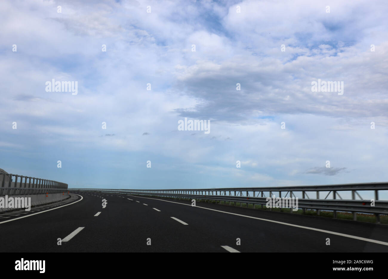 wide highway without cars and blue sky with clouds Stock Photo - Alamy