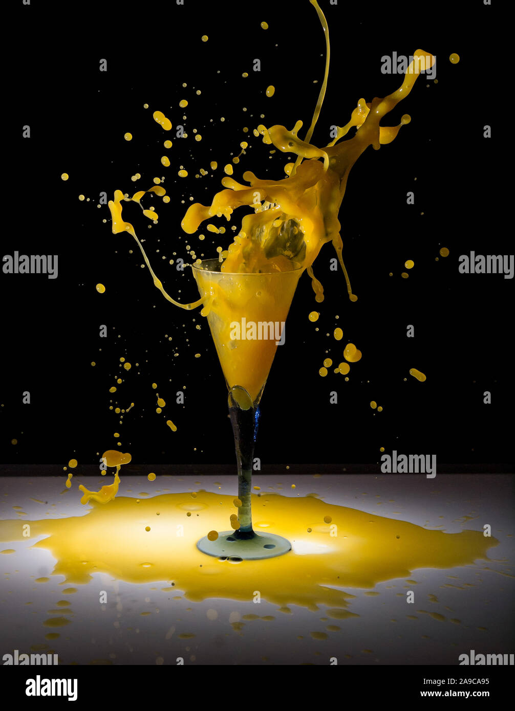 Drink cocktail peach juice splash of glass with frozen drops on a black ...