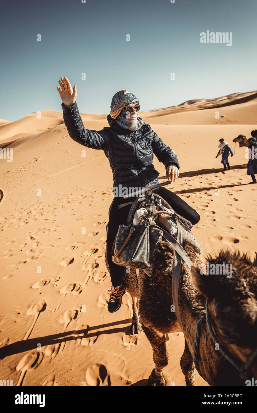 people riding dromedary through the desert Stock Photo - Alamy