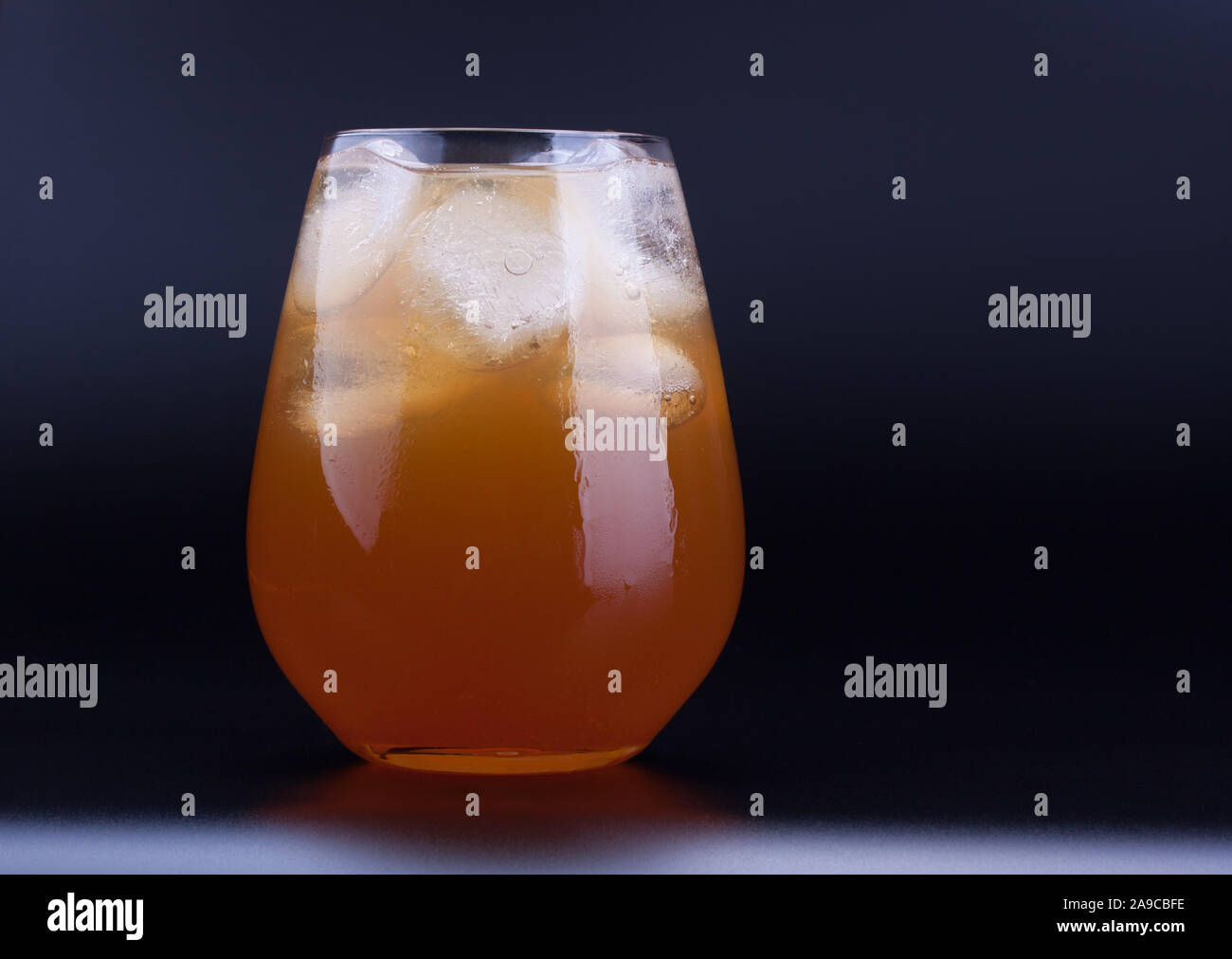 Big glass of ice tea with ice cubes, black background Stock Photo - Alamy