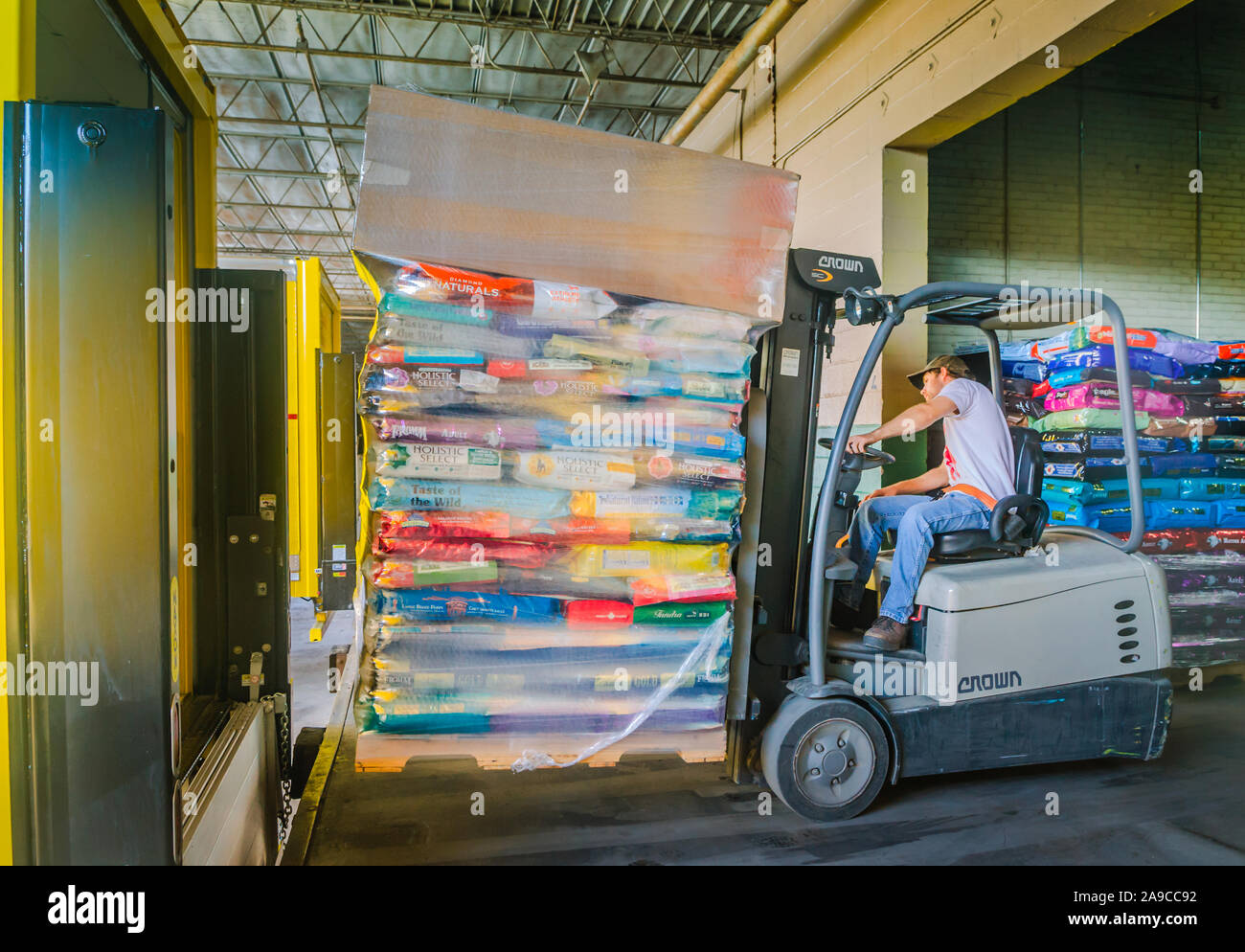 The assistant manager of Hollywood Feed loads a pallet of dog food at ...