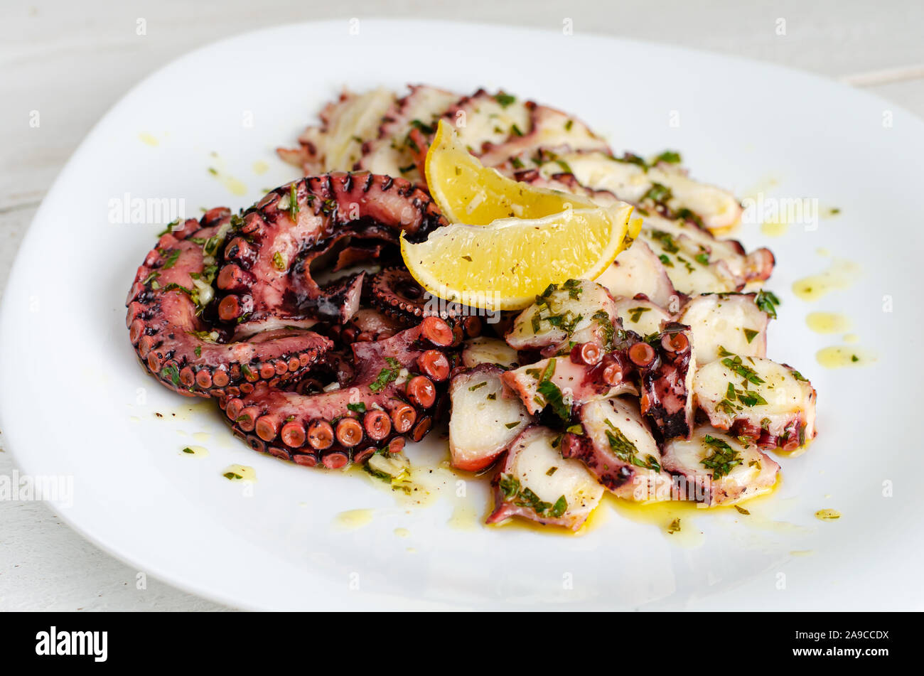 Delicious octopus carpaccio with dressing on white plate. Seafood ...
