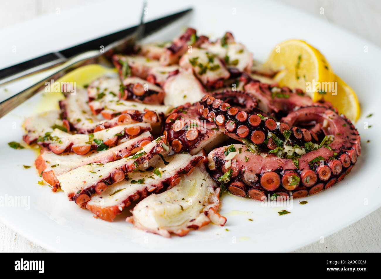 Seafood appetizer. Octopus Carpaccio on white plate. Mediterranean ...