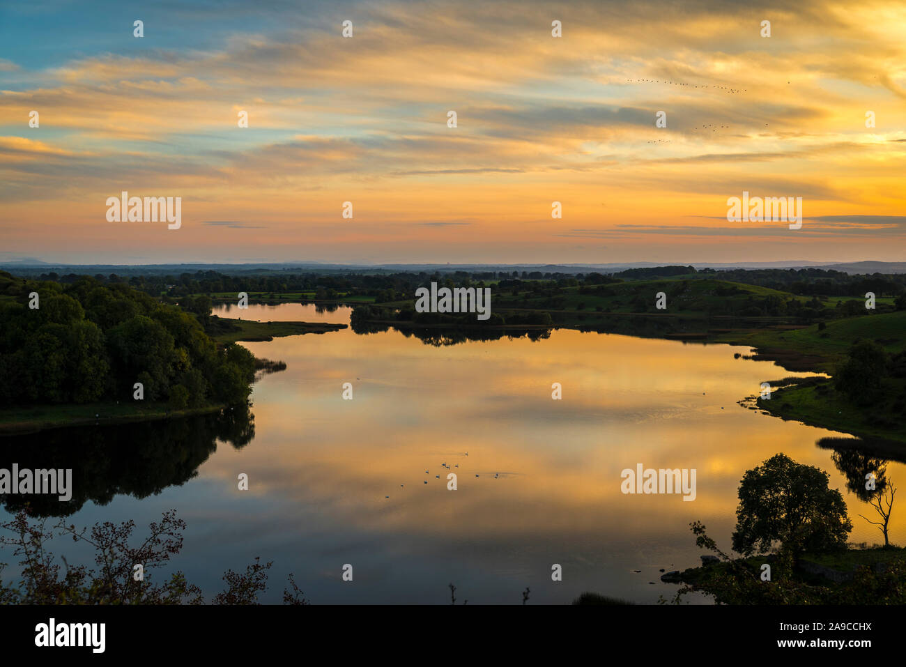 Sunset with yellow sky, mirror reflection on the lake surface ...