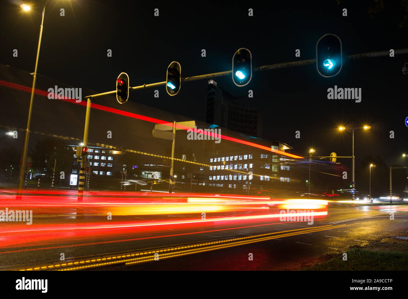 Intersection at night with traffic lights and traffic blurred by motion ...