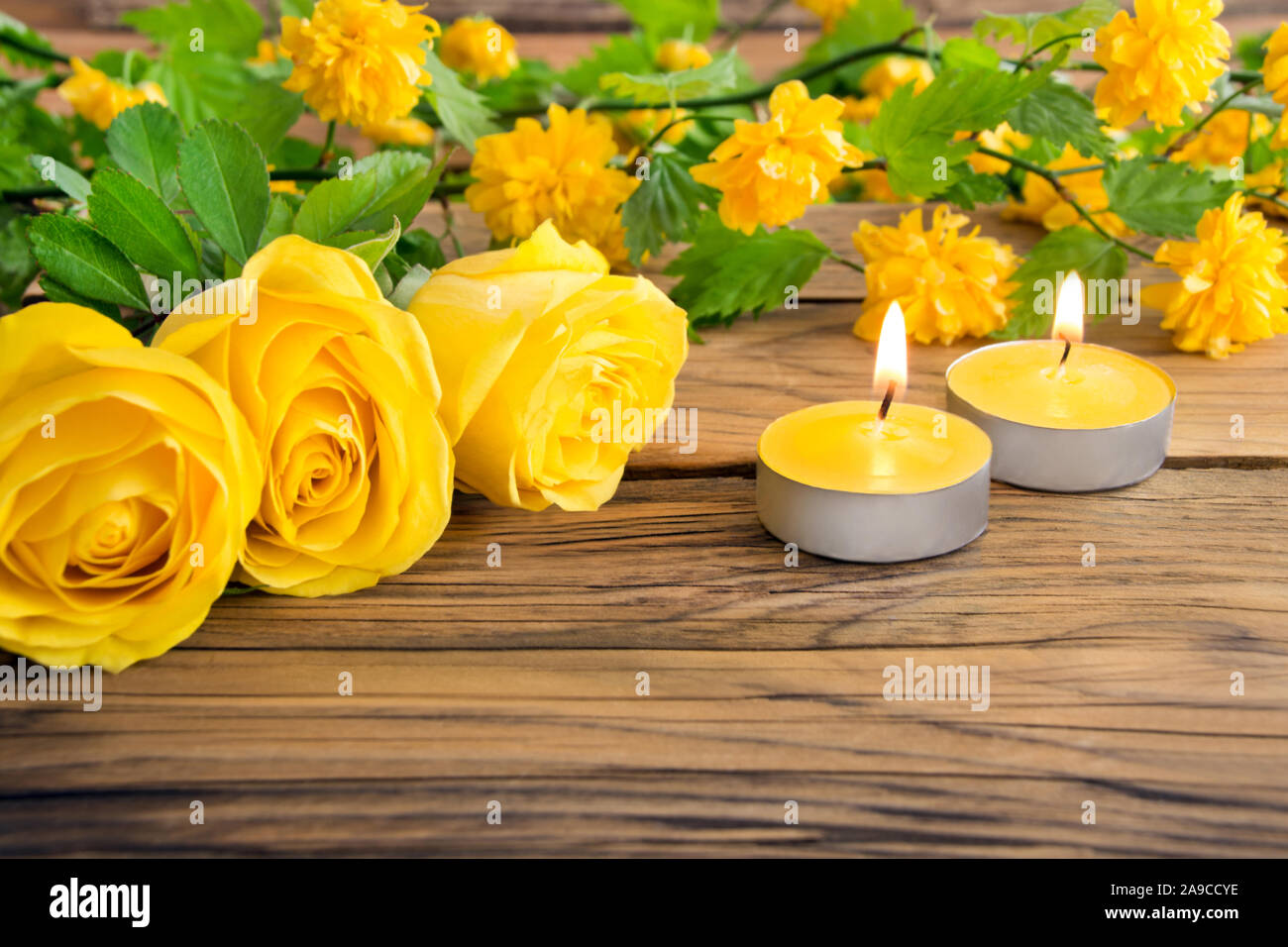 Yellow roses and two candles Stock Photo - Alamy