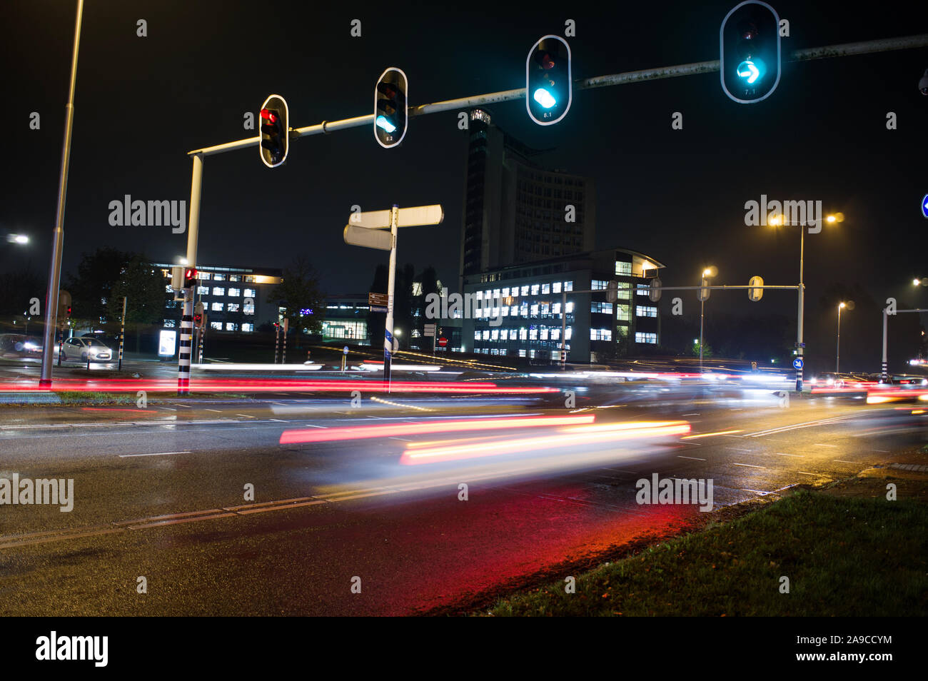 Intersection at night with traffic lights and traffic blurred by motion ...