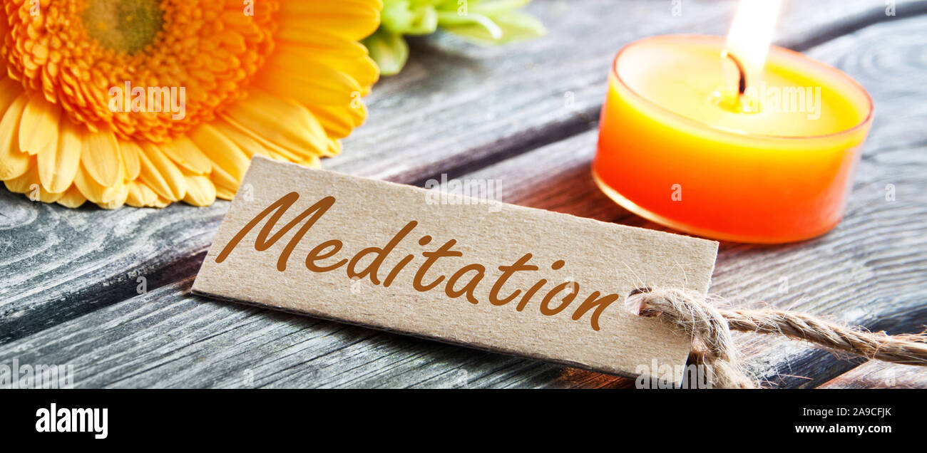 Meditation label and flowers with candle Stock Photo - Alamy