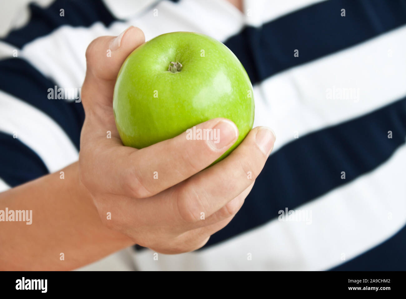 Male hand showing green apple Stock Photo - Alamy