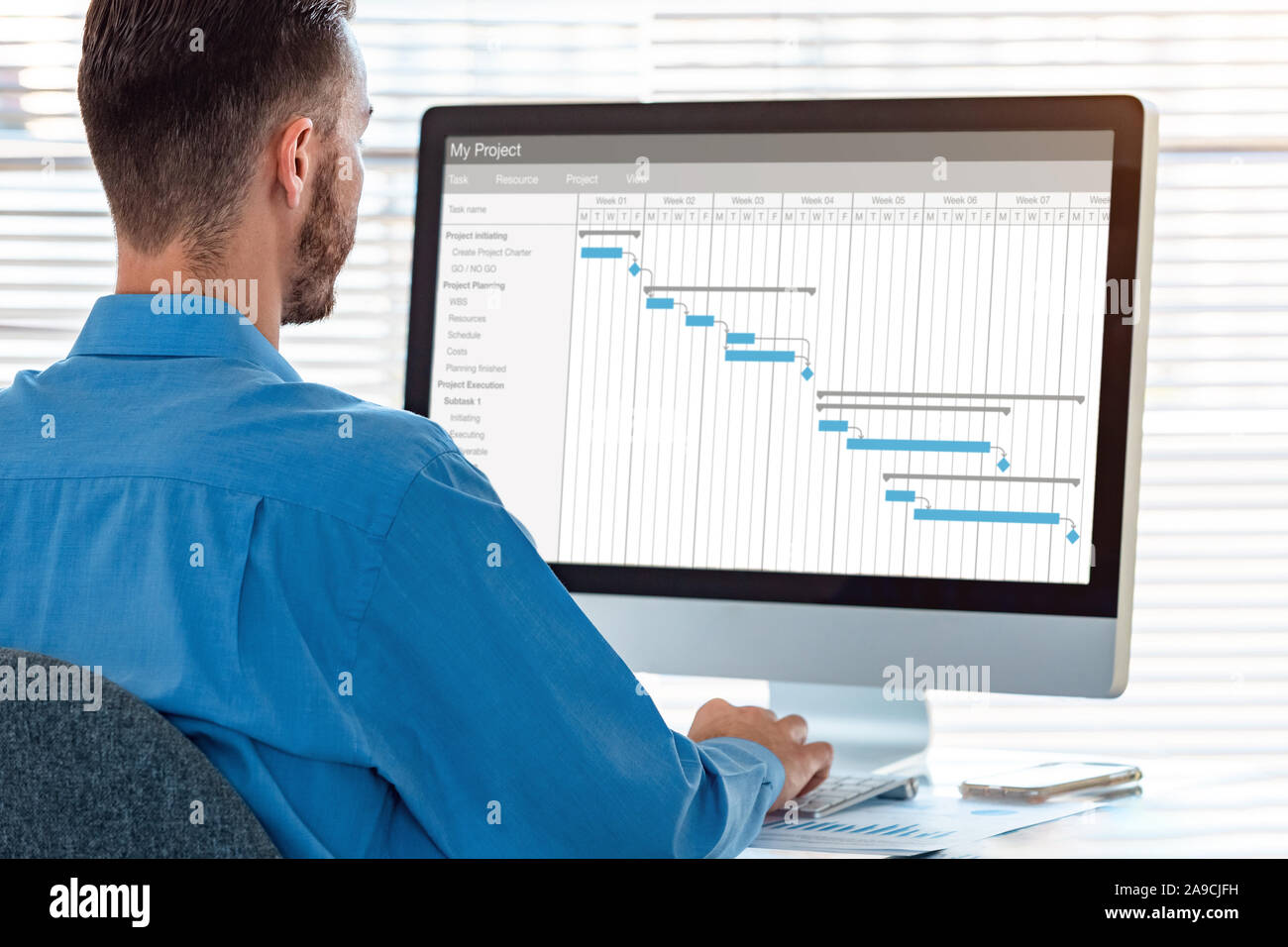 Project manager in office scheduling tasks and progression of ...