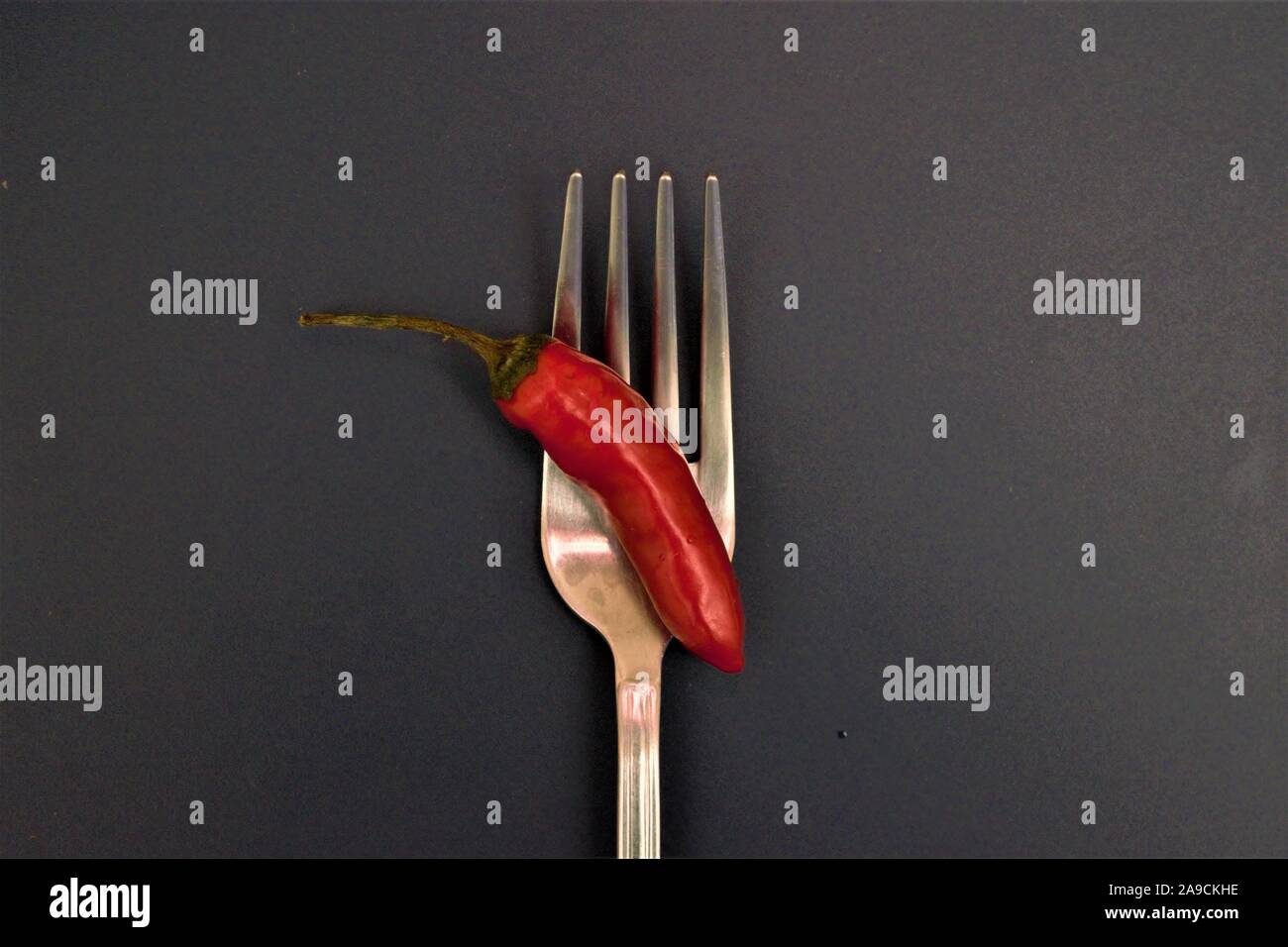 red chili pepper and metal fork and knife Stock Photo - Alamy