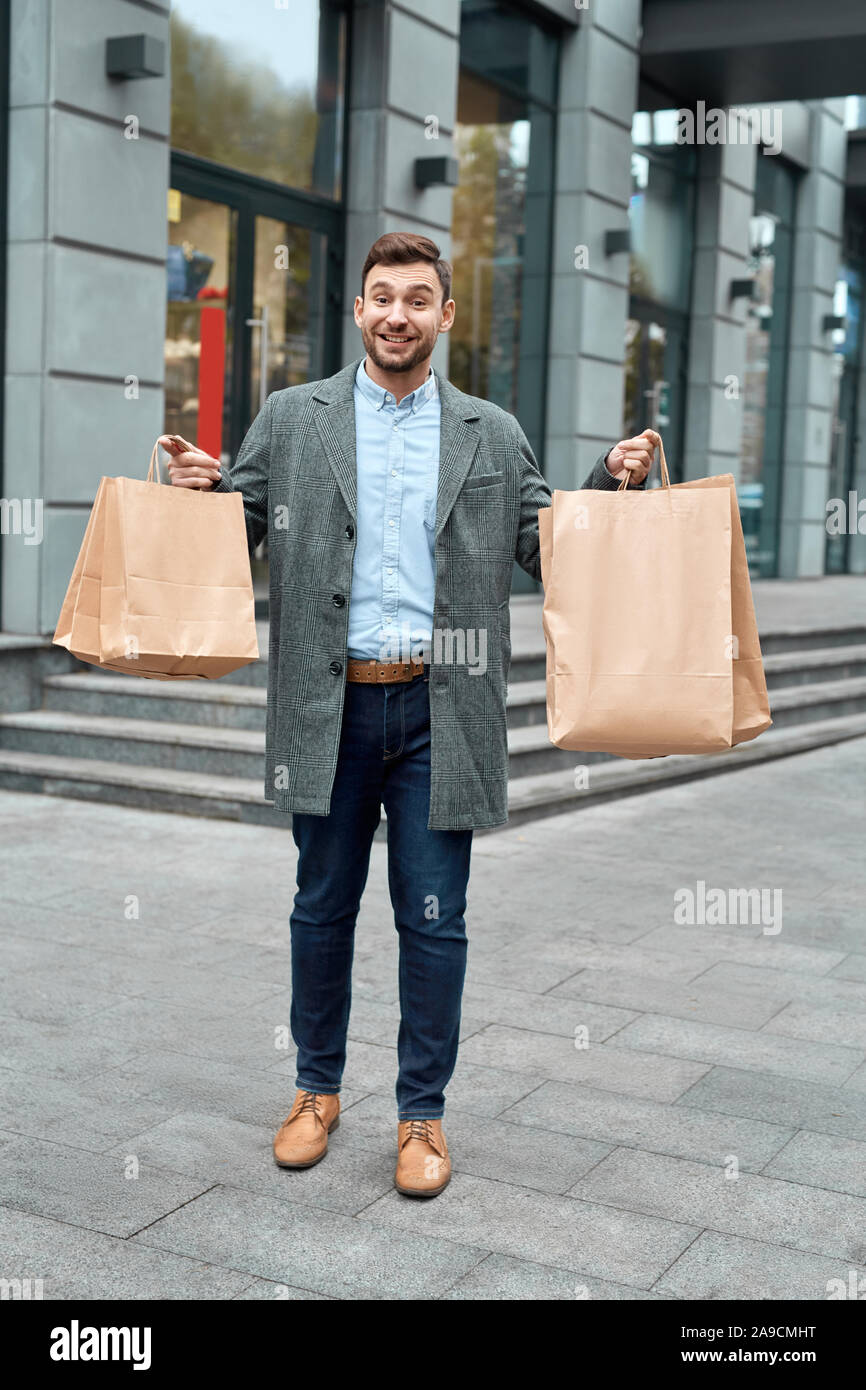 Happy man showing shopping bags hi-res stock photography and images - Alamy