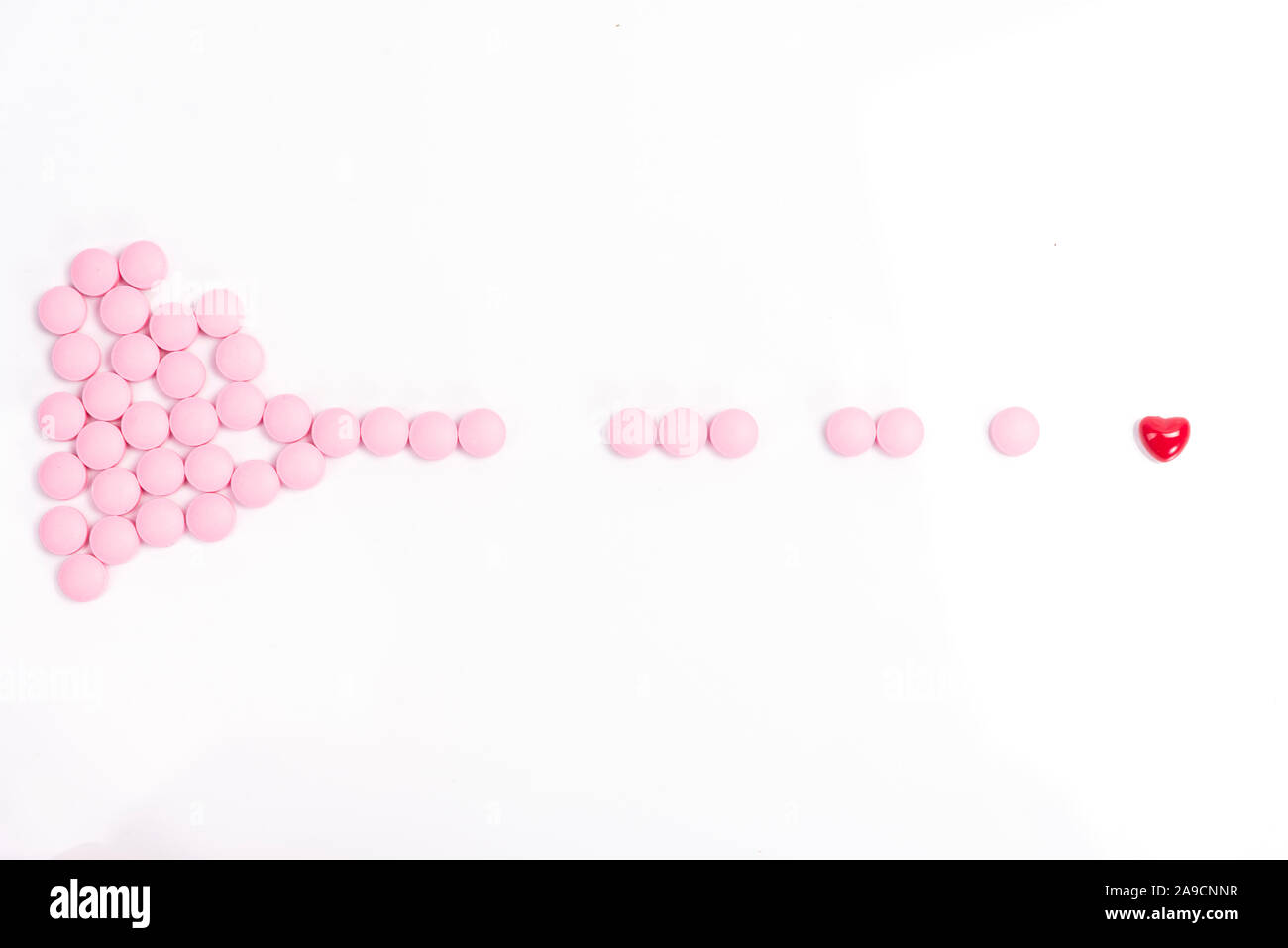 Pink pills on a white background with a red heart. Heart pills Stock ...