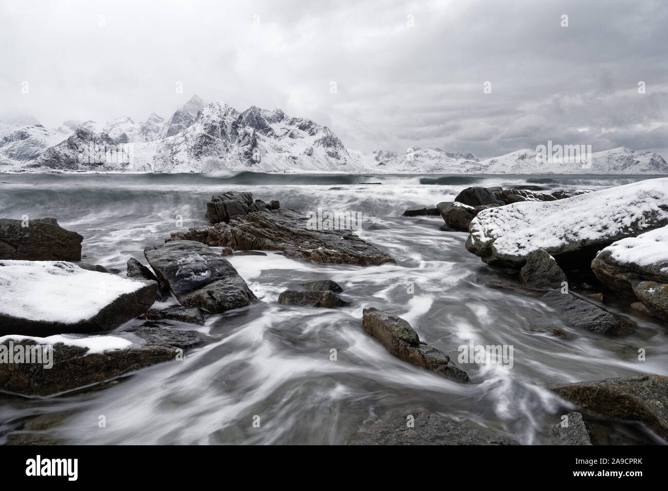 Coastal landscape in winter with water movement between large stones ...